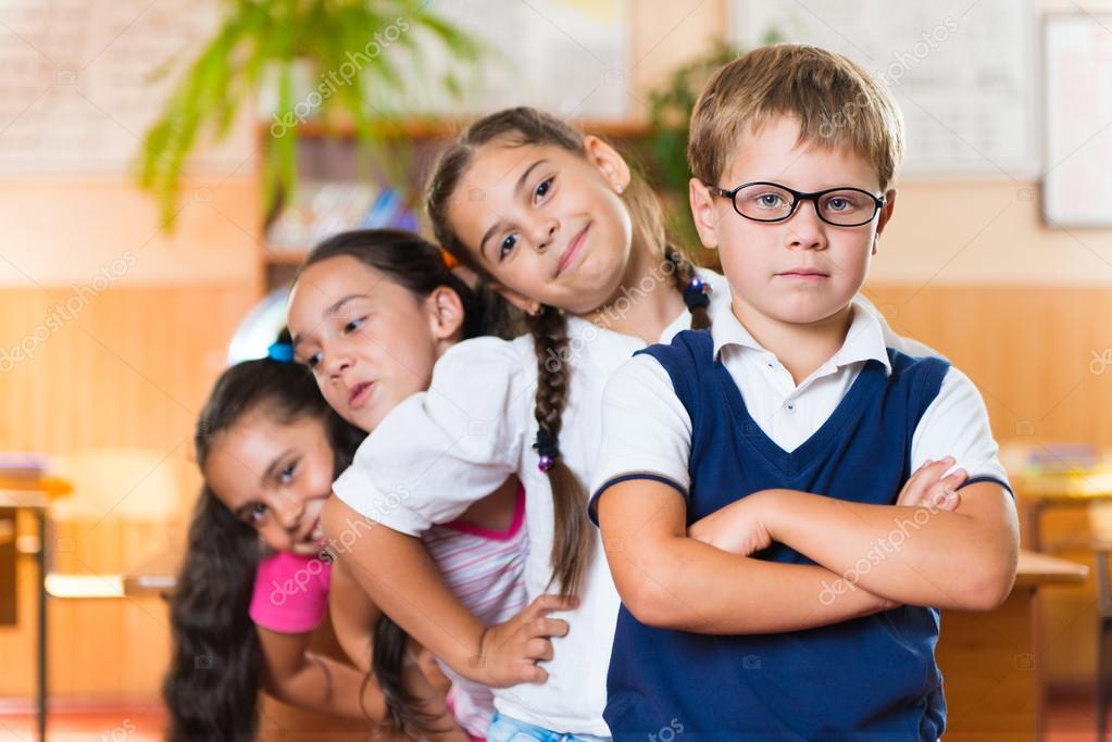 Four adorable schoolchildren standing in classroom Stock Photo by ...