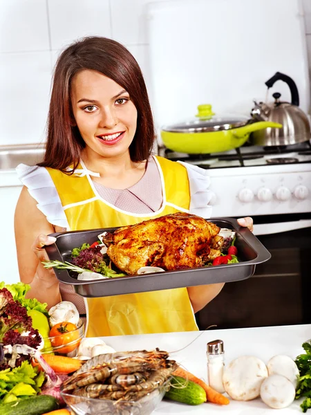 Woman cooking chicken at kitchen. Stock Photo by ©poznyakov 104524796