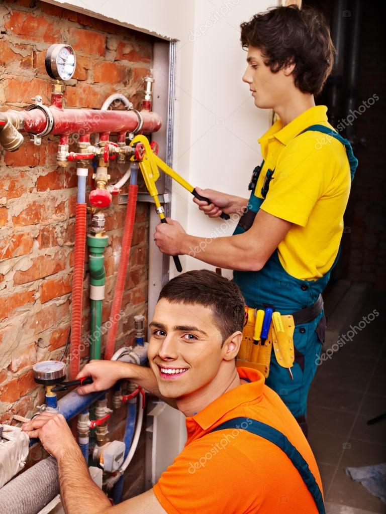 Repairmеn fixing heating system . Stock Photo by ©poznyakov 47787519