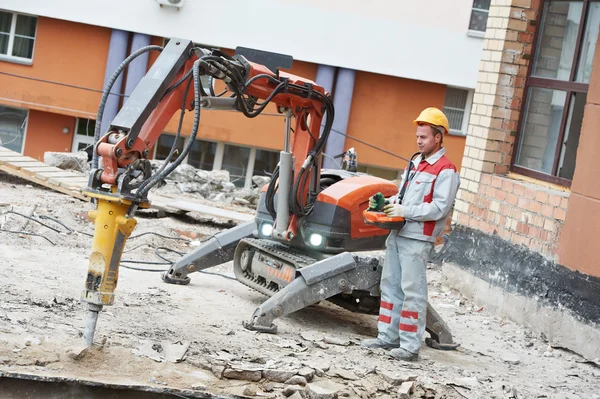 Builder worker operating demolition machine Stock Photo by ©kalinovsky ...