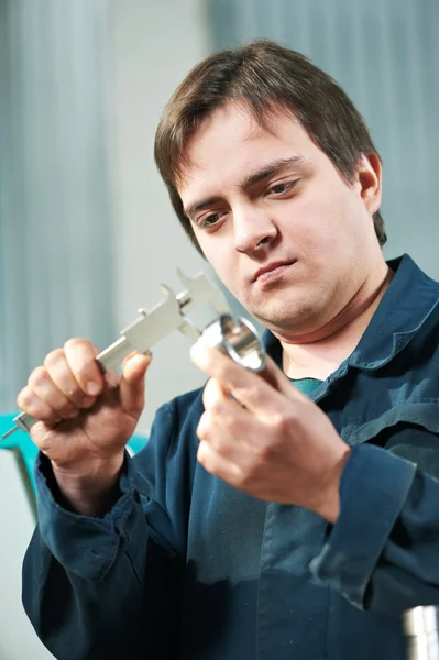 Worker measuring detail with caliper - Stock Image - Everypixel