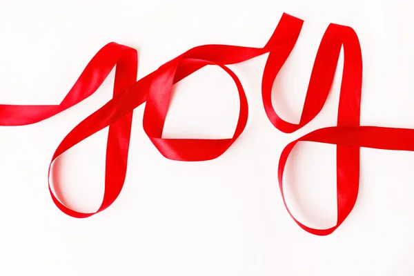 Joy word written in red ribbon — Stock Photo © Shebeko #36530015