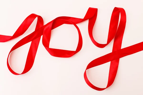 Joy word written in red ribbon — Stock Photo © Shebeko #36530015