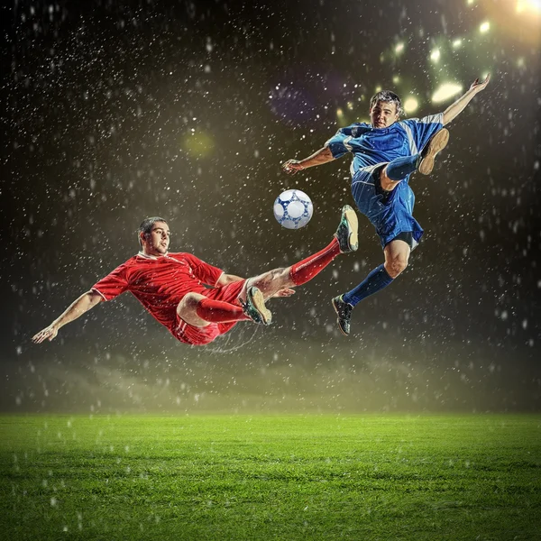 Two football players striking the ball Stock Photo by ©SergeyNivens ...