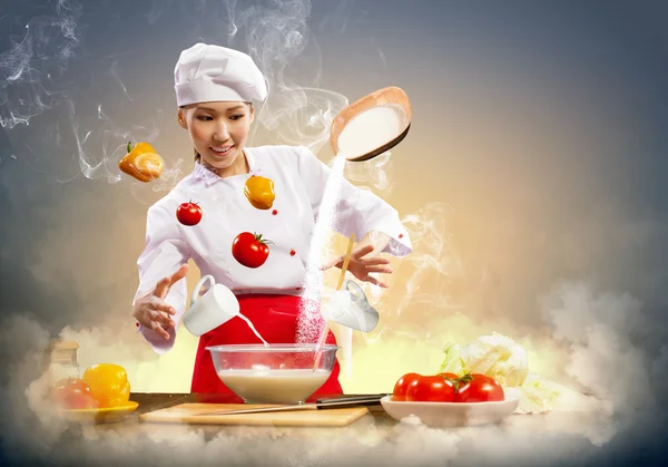 Asian female cooking with magic — Stock Photo © SergeyNivens #21137389