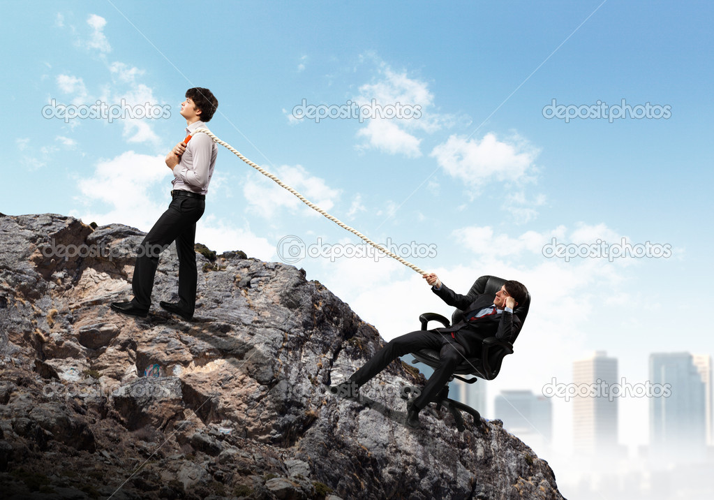 Two businessmen pulling rope atop of mountain Stock Photo by ...