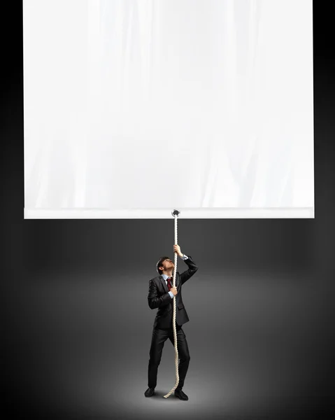 Businessman pulling blank banner Stock Photo by ©SergeyNivens 26371591