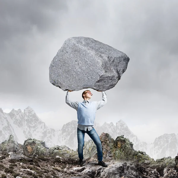 Guy lifting stone Stock Photo by ©SergeyNivens 50193279