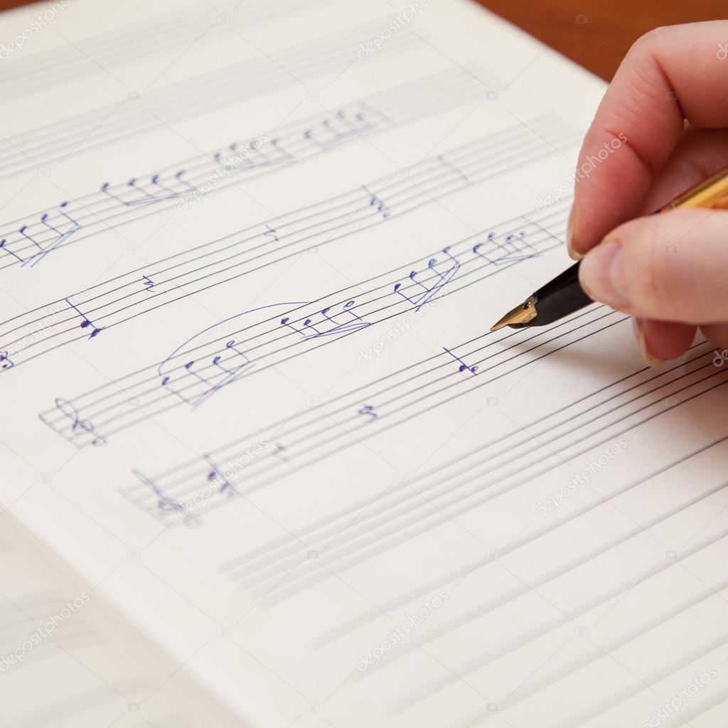 Hand with pen and music sheet — Stock Photo © Djemphoto #42806561