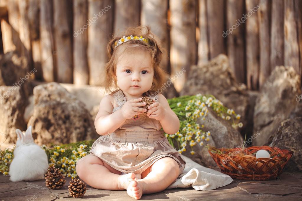Little girl playing with rabbit in the village. Outdoor. Summer ...