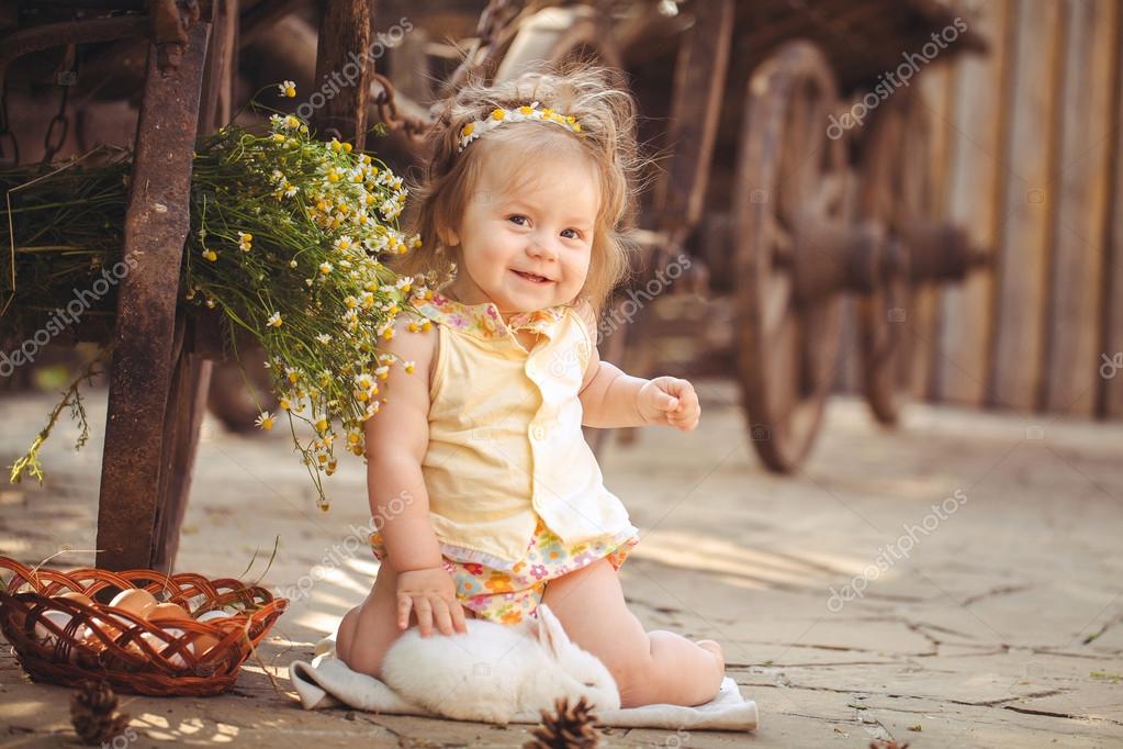 Little girl playing with rabbit in the village. Outdoor. Summer ...