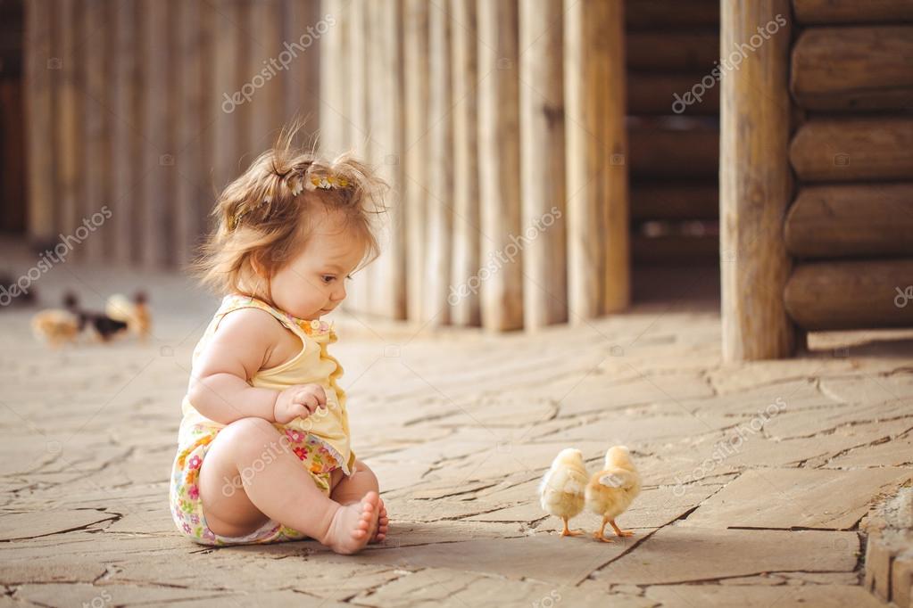 Little girl playing with rabbit in the village. Outdoor. Summer ...