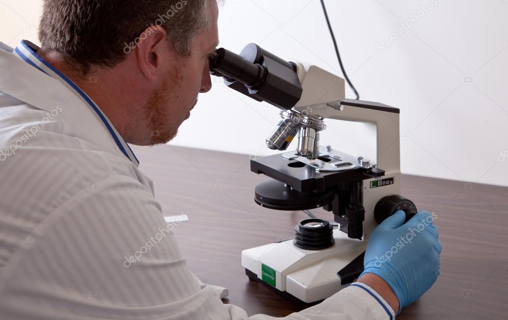 Lab scientist looks into microscope Stock Photo by ©vittore 14671911