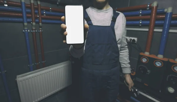 White blank screen on phone in plumber's hand in protection gloves ...