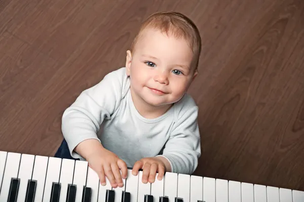 Baby play music on piano keyboard Stock Photo by ©vkraskouski 28621293
