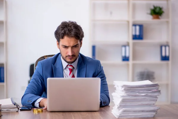 Young businessman employee and too much work at workplace - Stock Image ...
