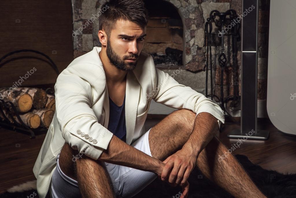 Young attractive bearded men in white suit pose in modern room. Stock ...