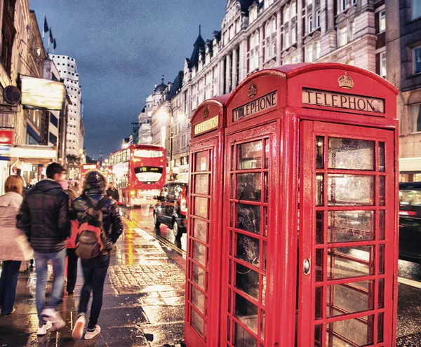 Red Telephone Booth in London on a crowded street at night Stock Photo ...