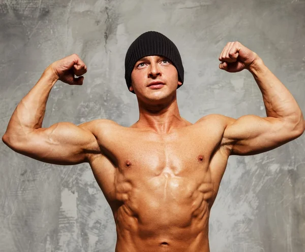 Handsome man with muscular torso in beanie hat posing - Stock Image ...