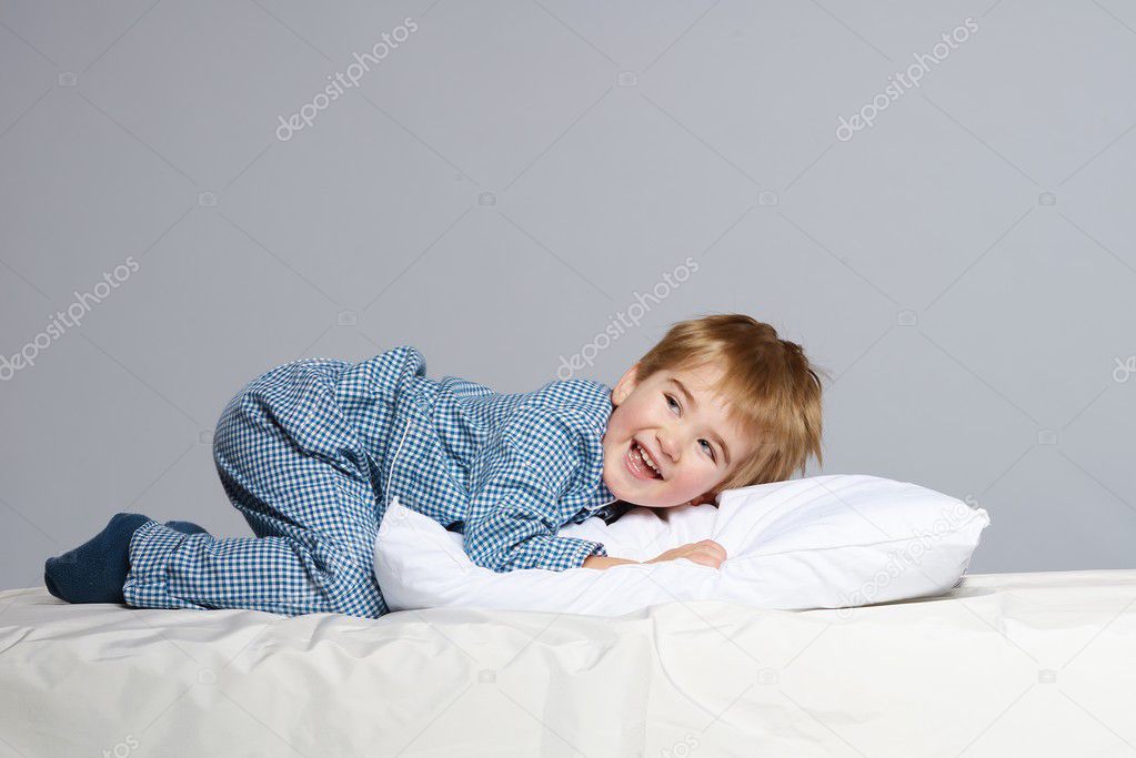 Little boy wearing blue pyjamas in bed Stock Photo by ©nejron 40761231