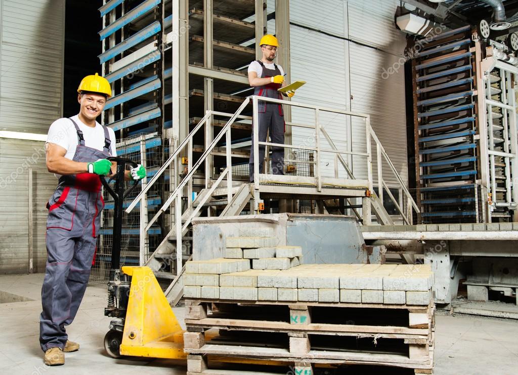 Young worker moving paving stones with pallet truck on a factory Stock ...