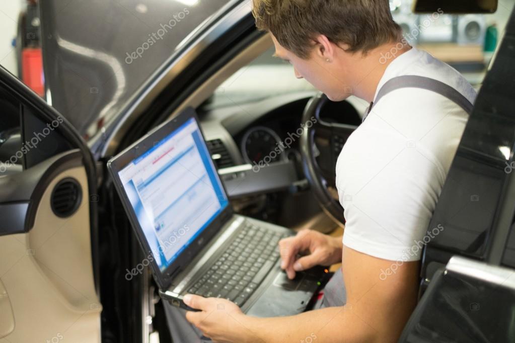 Serviceman making car diagnostics with laptop in a workshop — Stock ...
