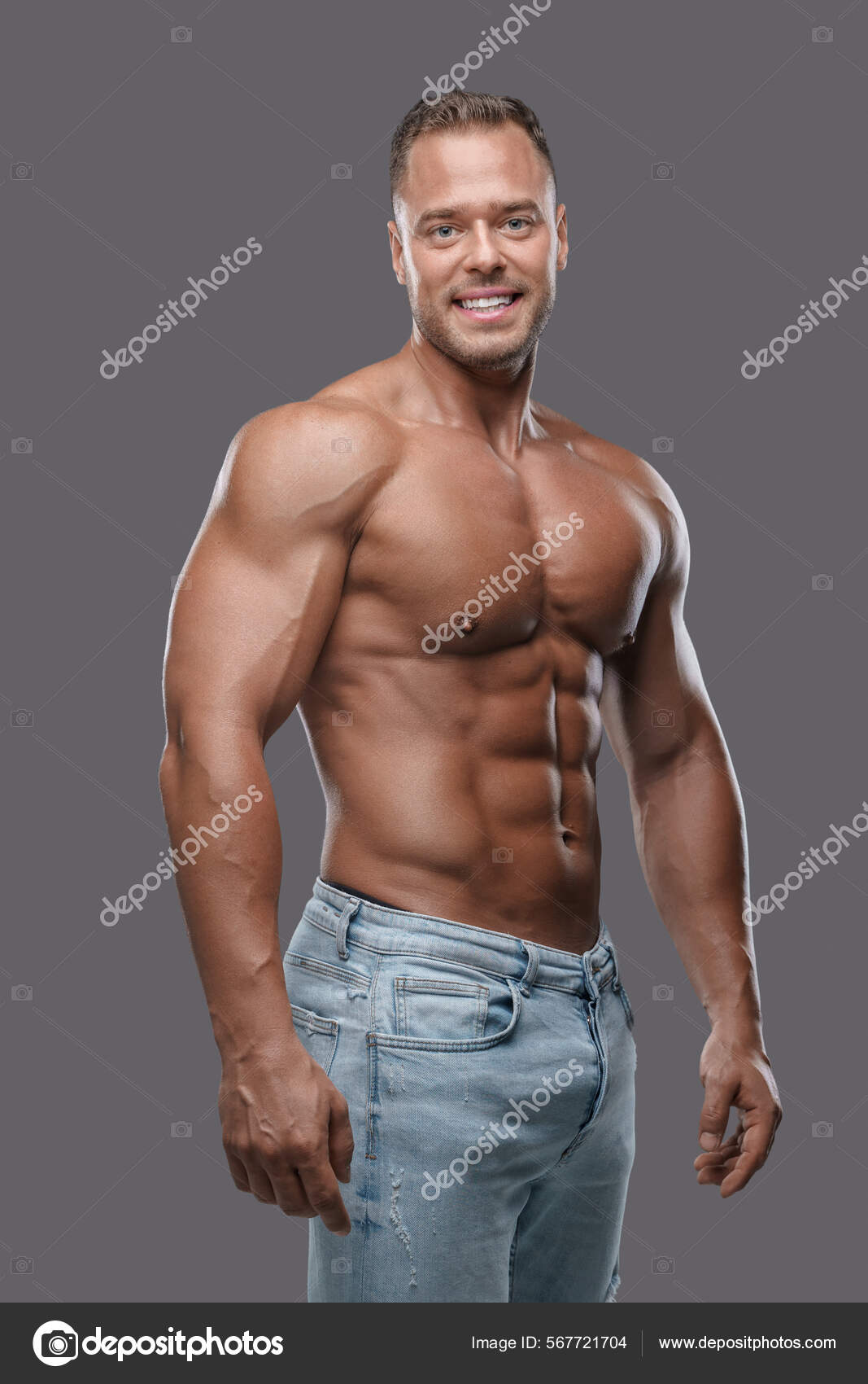 Happy bodybuilder with naked torso posing against gray background ...