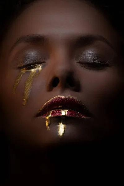 Gold on the skin, face art and creative makeup, gold as tears and blood ...