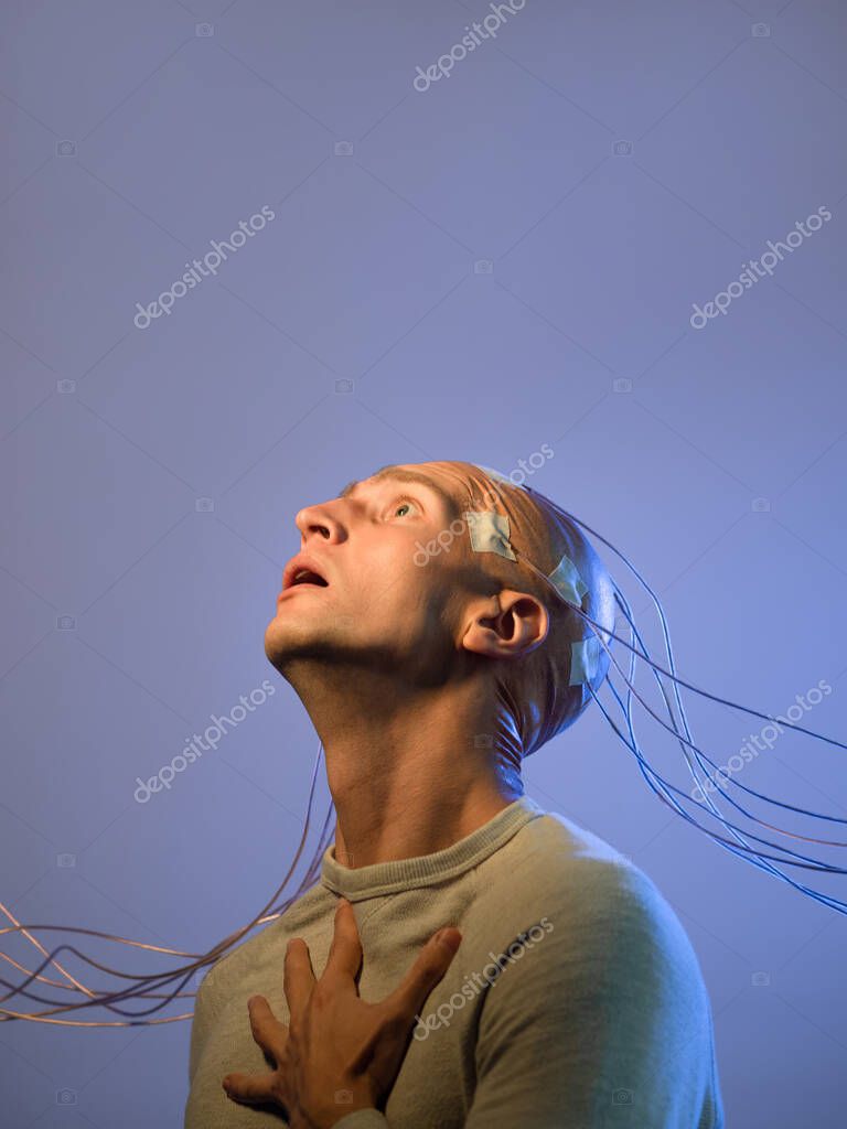 Un joven con la cabeza enredada en cables, experimentando dolor y ...