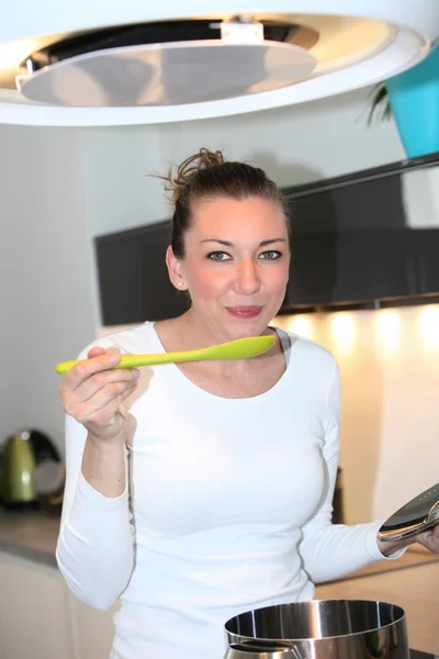 Woman doing a taste test while cooking - Stock Image - Everypixel
