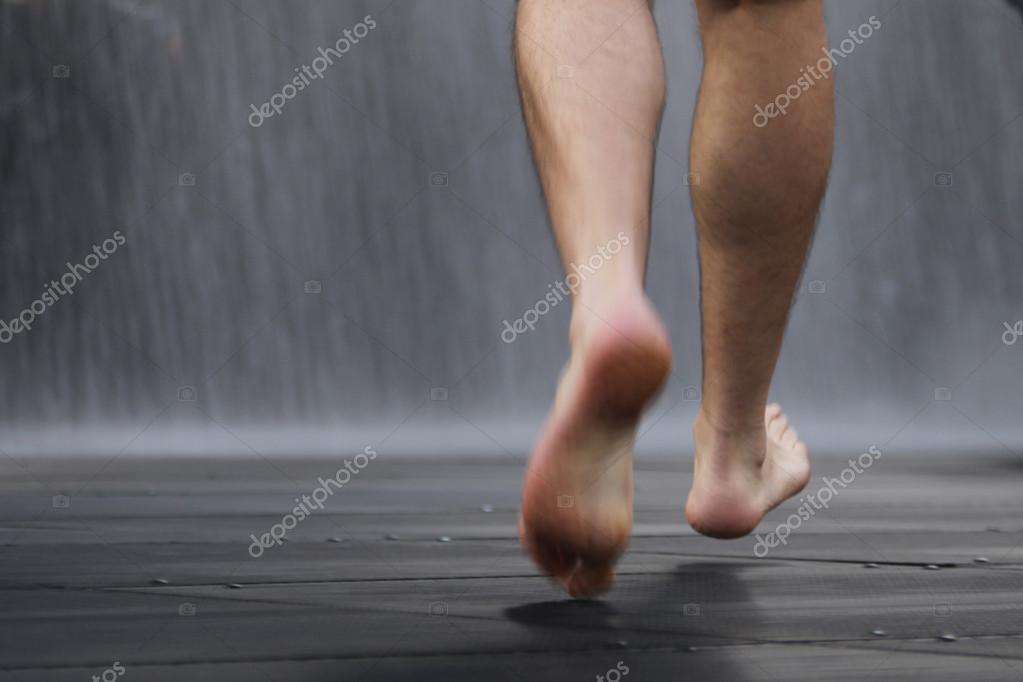 Man walking in the rain barefoot Stock Photo by ©Jenkins 33460893
