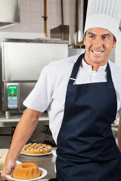 Male Chef Holding Baked Cake In Kitchen - Stock Image - Everypixel