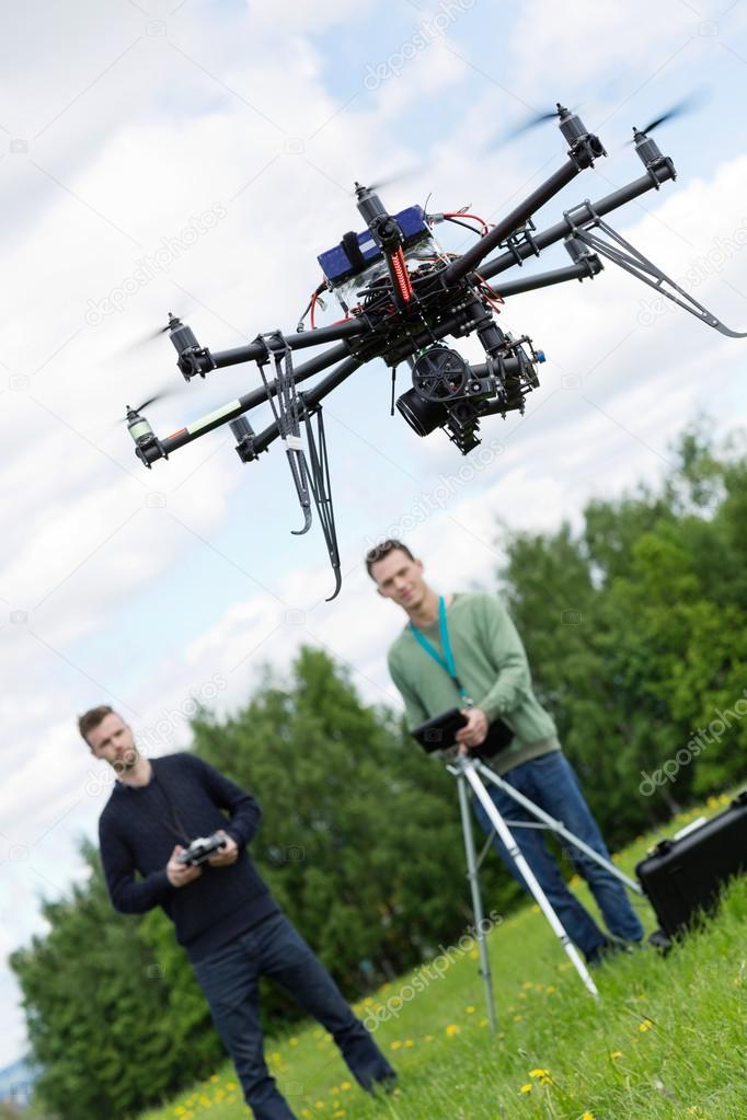 Engineers Operating UAV Octocopter in Park — Stock Photo © SimpleFoto ...
