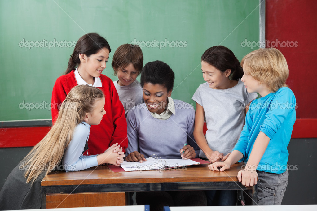Profesora enseñando a los escolares en el escritorio — Foto de stock ...