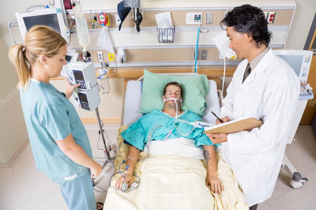 Médico y enfermera examinando paciente crítico 2023