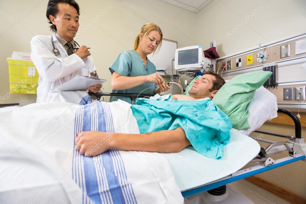 médico y enfermera examinando a paciente hospitalizado — Foto de stock ...
