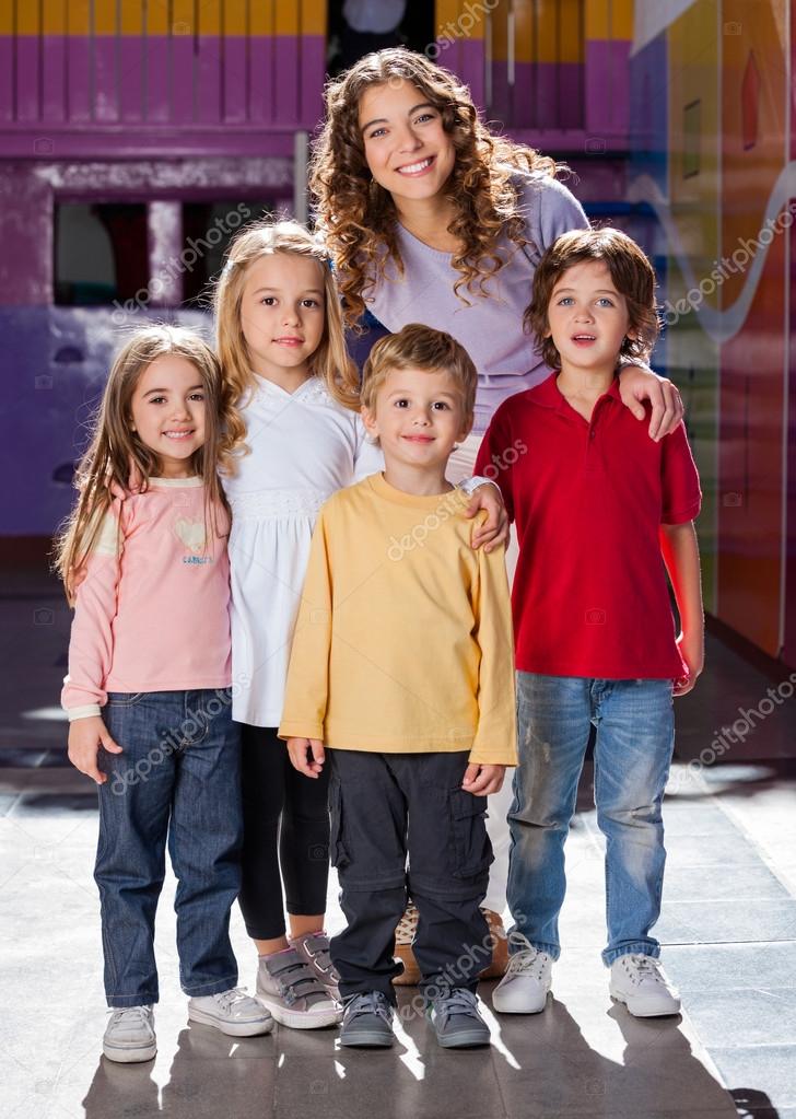 Cute Little Children With Teacher In Kindergarten — Stock Photo ...