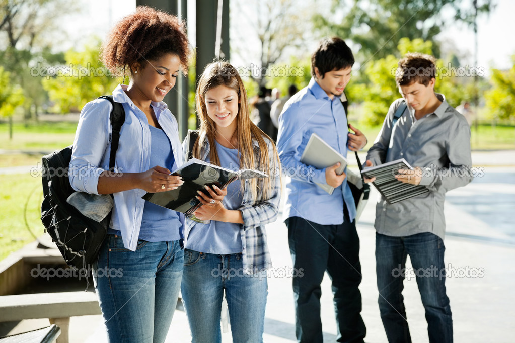 Estudiantes leyendo libros en campus universitario — Foto de Stock ...