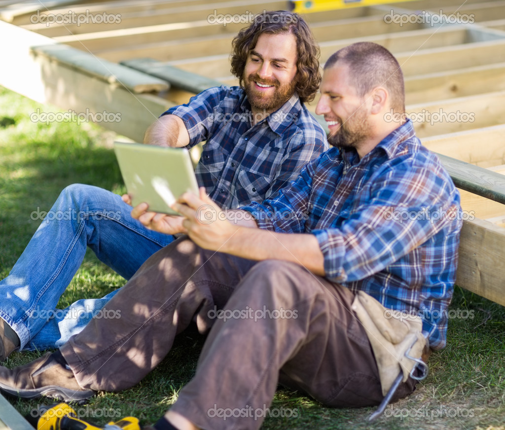 Happy Carpenters Using Digital Tablet At Construction Site Stock Photo ...
