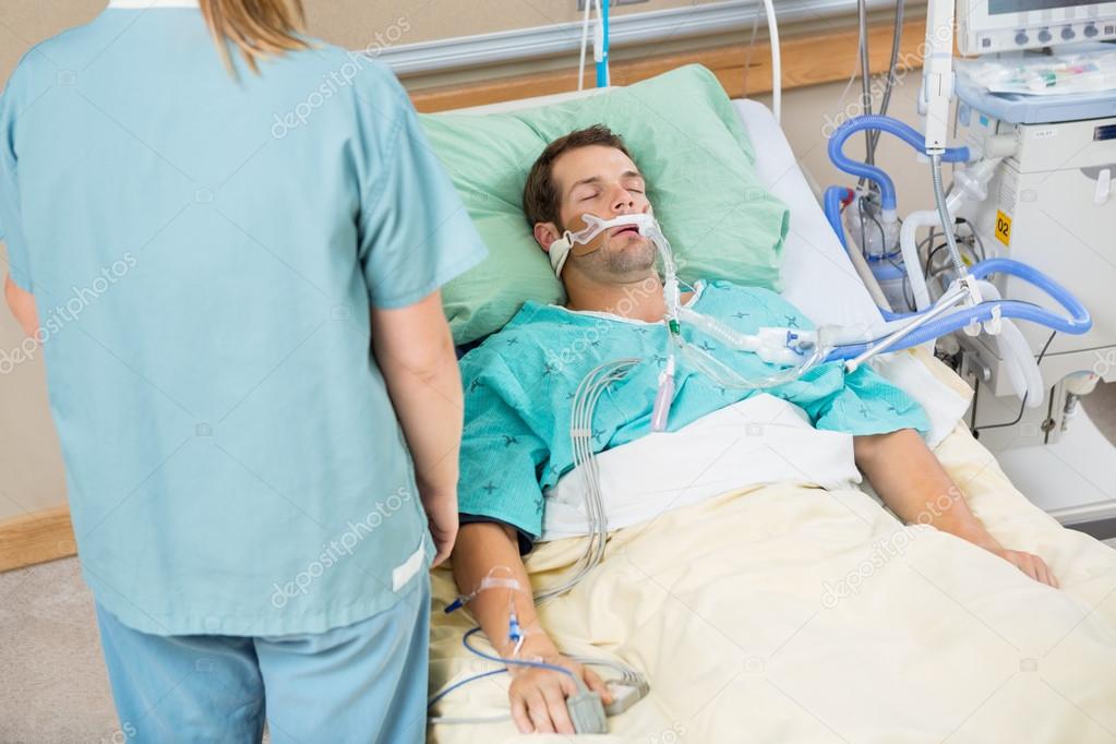 Patient Sleeping With Nurse Standing By Stock Photo by ©SimpleFoto 34277053
