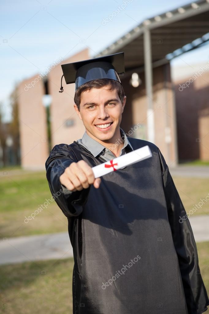 Man In Graduation Gown Showing Diploma On University Campus — Stock ...