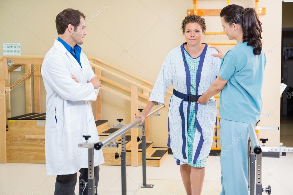 Physical Therapist With Doctor Assisting Female Patient In Walki — Stock Photo © SimpleFoto ...
