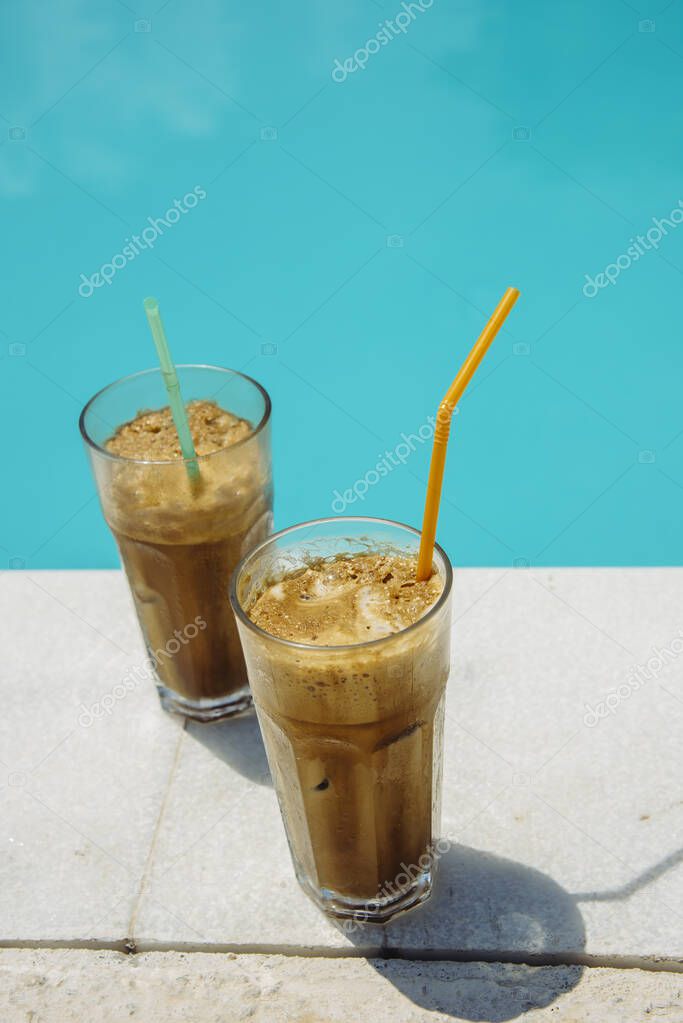 Vacaciones de verano con refresco de frappe junto a la piscina de lujo ...
