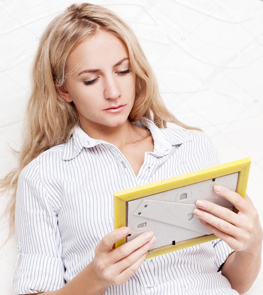 Woman looking at a frame with photos — Stock Photo © TatyanaGl #38579103