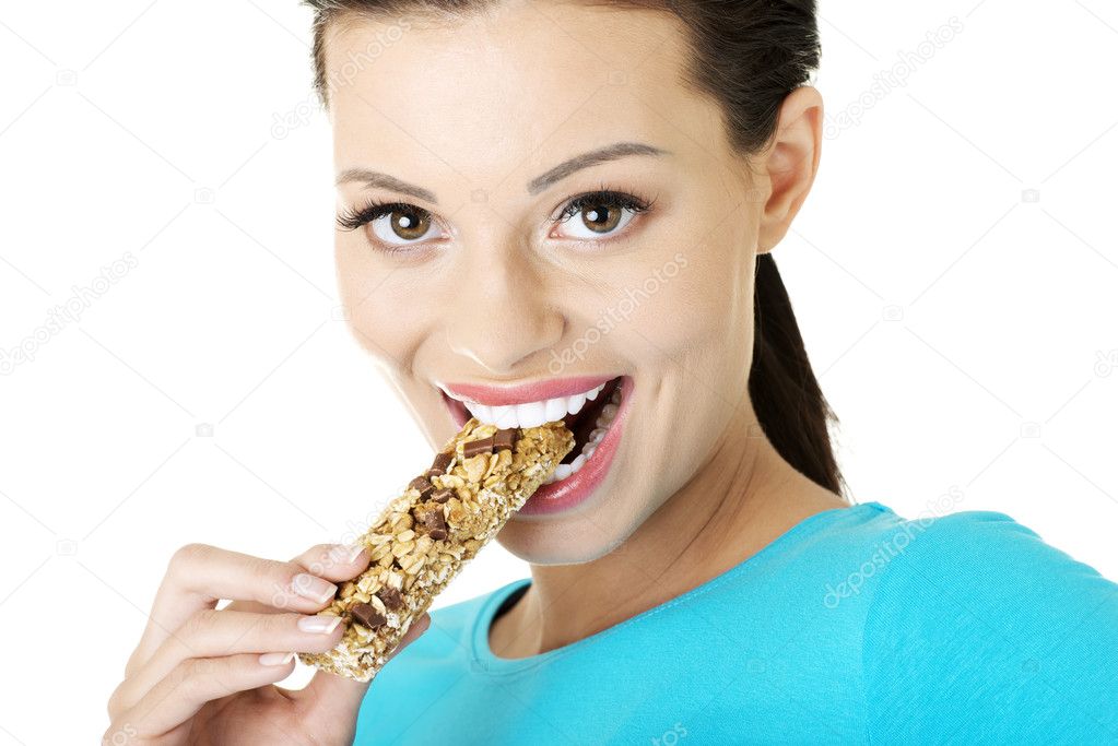 Young woman eating cereal candy bar Stock Photo by ©piotr_marcinski ...