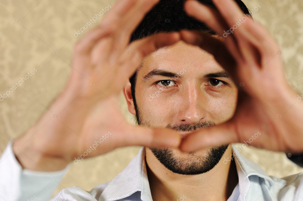 Young the man looks through a frame combined of fingers. — Stock Photo ...