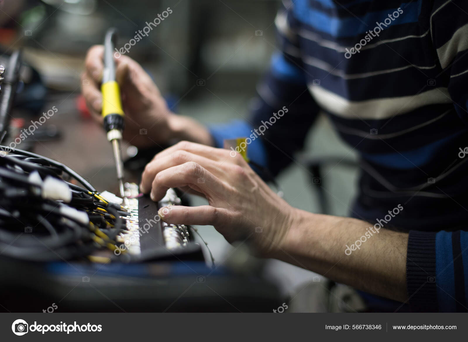 Industrial worker man soldering cables of manufacturing equipment in a ...