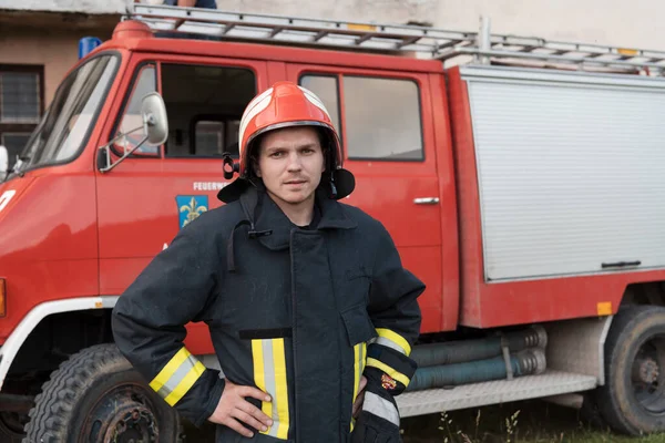 Firefighter with uniform and helmet stand in front of electric wire on a roof top. High quality ...