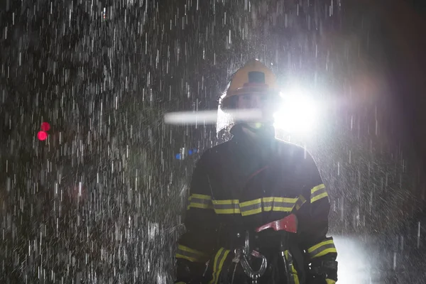 Portrait of a female firefighter standing and walking brave and optimistic. Heavy rain is good ...