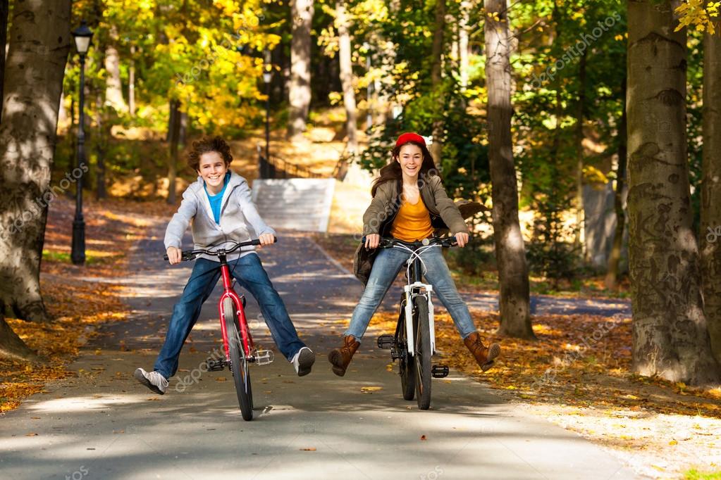 Urban biking - teens riding bikes in city park Stock Photo by ©gbh007 ...
